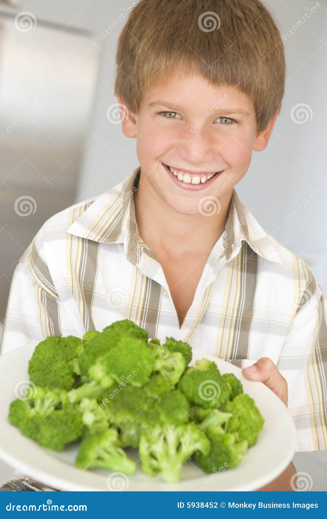 Young Boy in Kitchen Eating Broccoli Smiling Stock Photo - Image of ...