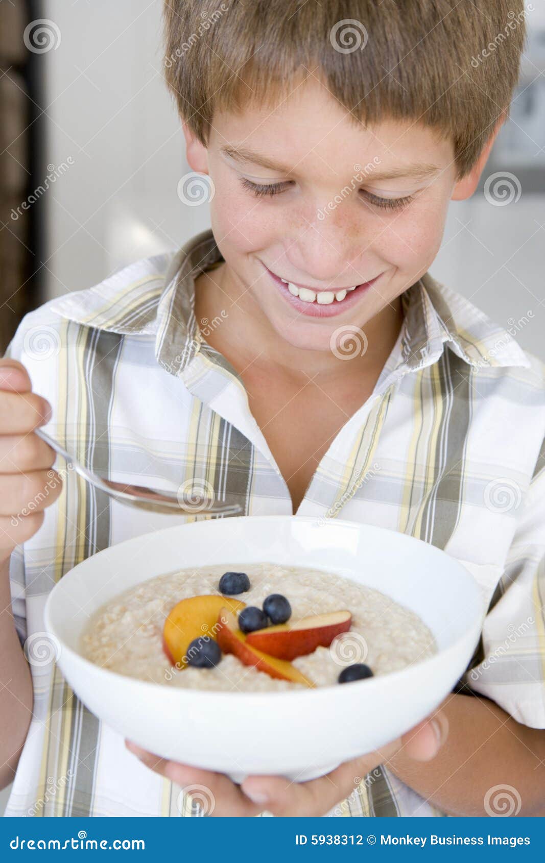 Young Boy in Kitchen Eating Oatmeal with Fruit Smi Stock Photo - Image ...