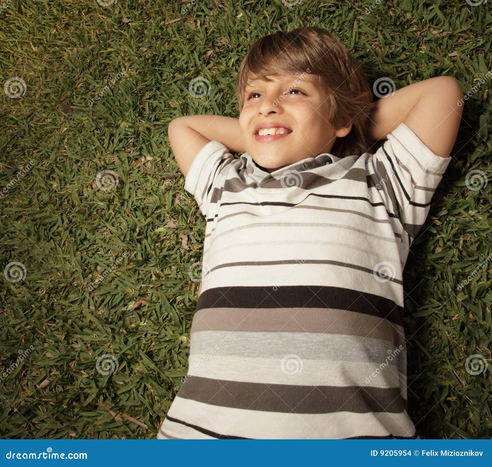 Young boy laying on grass stock photo. Image of young - 9205954