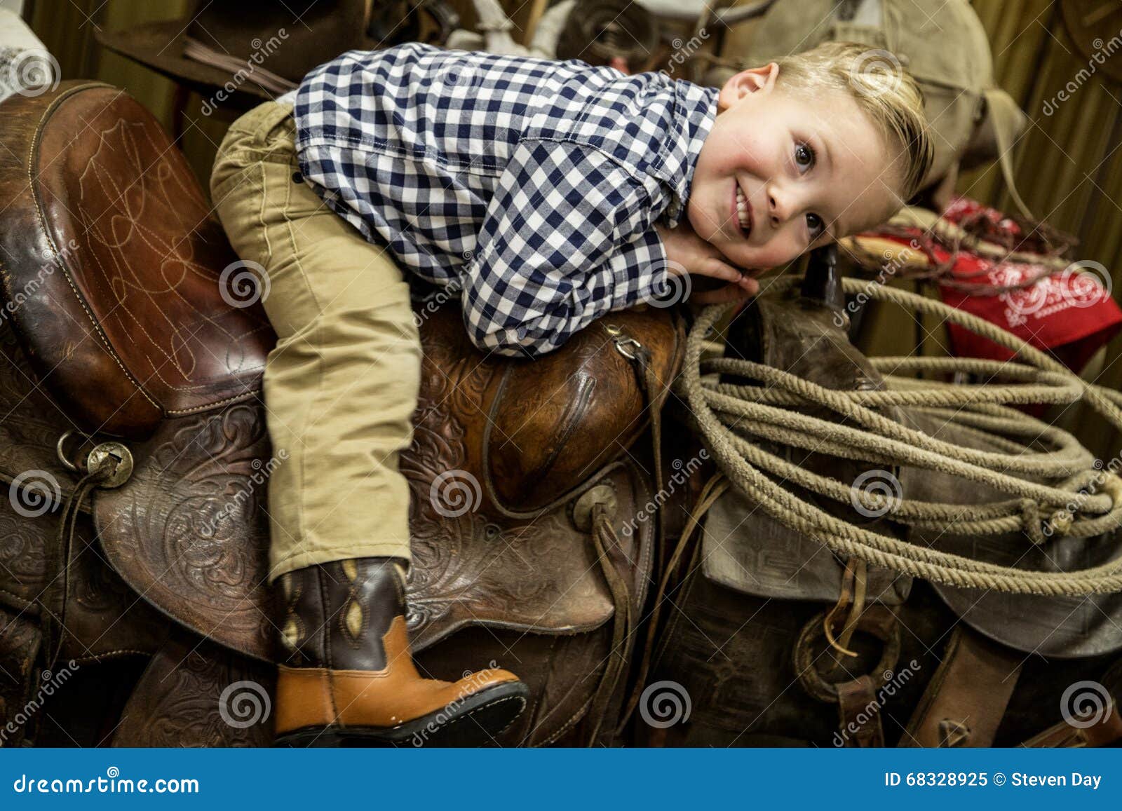 Young Boy Laying on a Western Cowboy Saddle Smiling Stock Image - Image ...