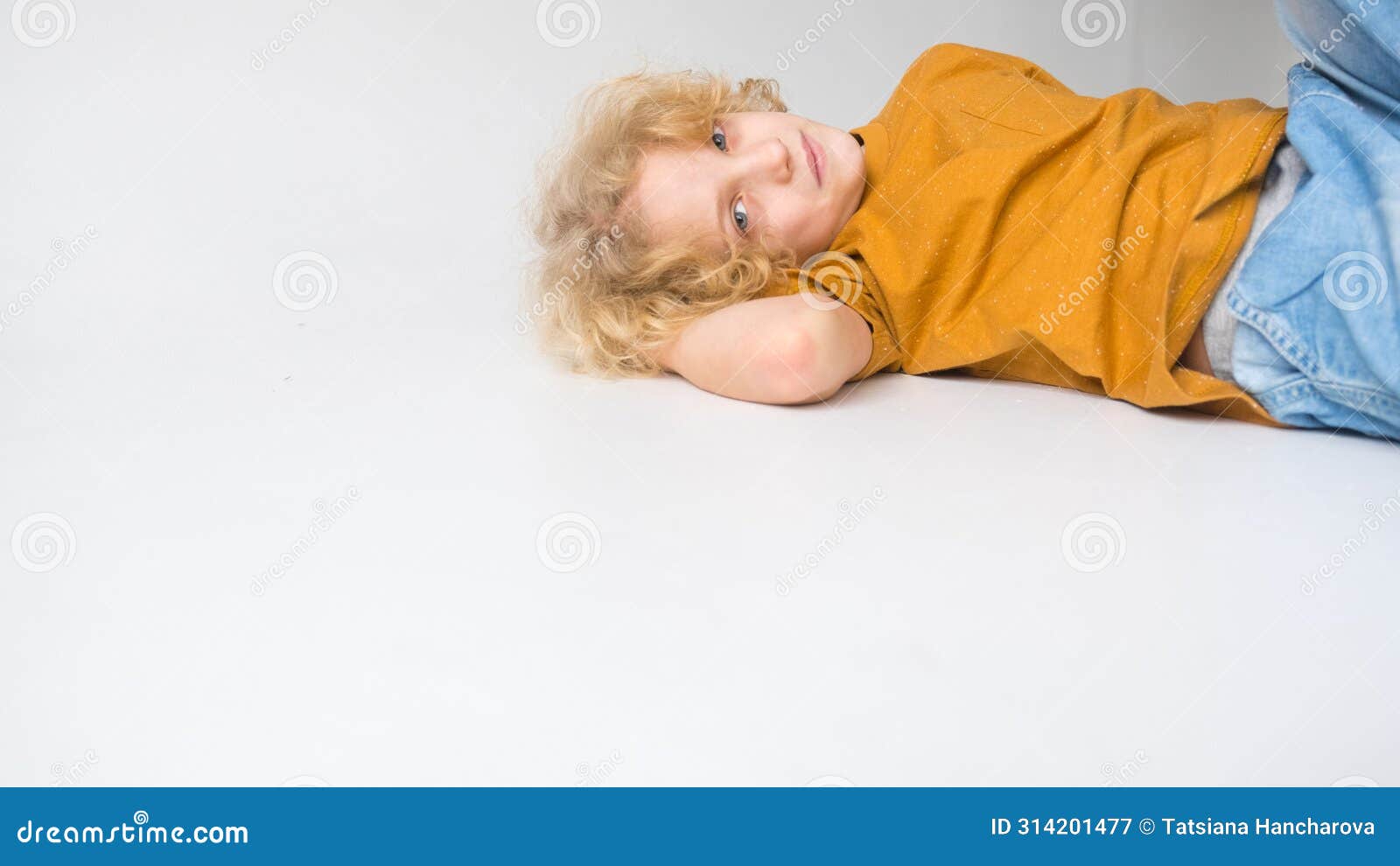 Young Boy Lying Down Casually in a Bright Studio Setting Stock Image ...