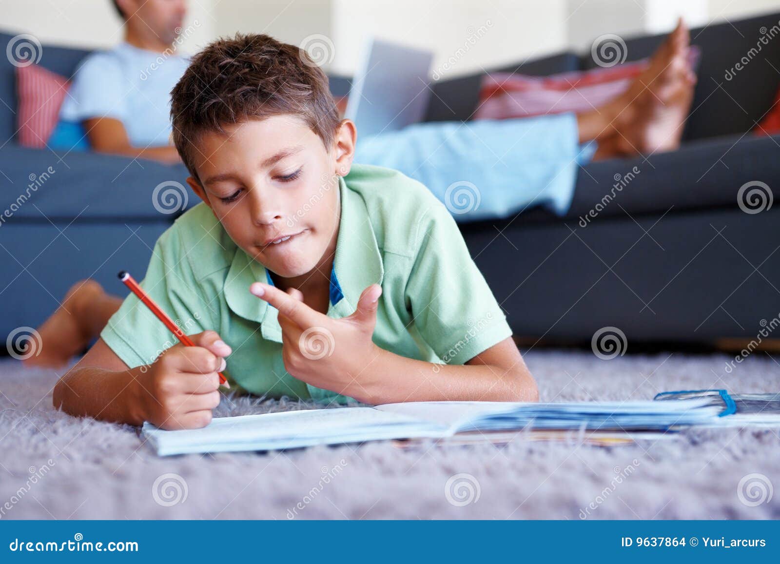 Young Boy Lying on the Floor and Doing Homework Stock Photo - Image of ...