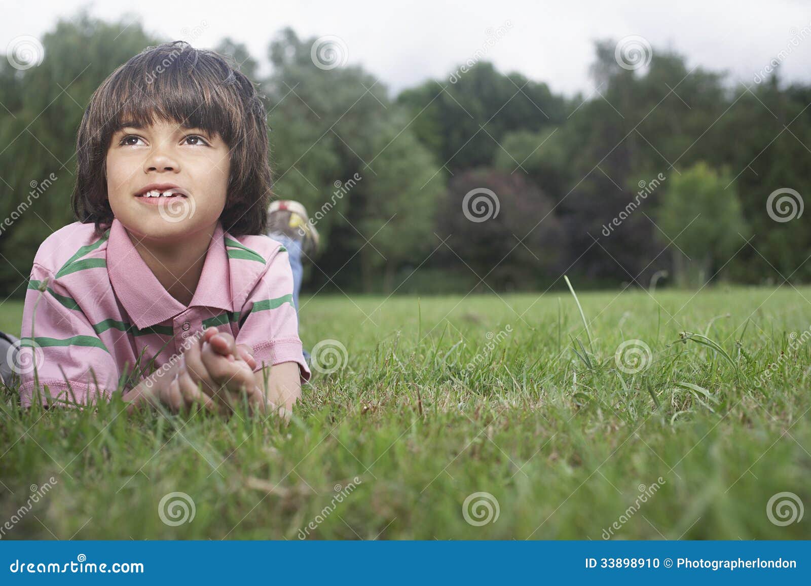 Young Boy Lying in Meadow stock photo. Image of cute - 33898910