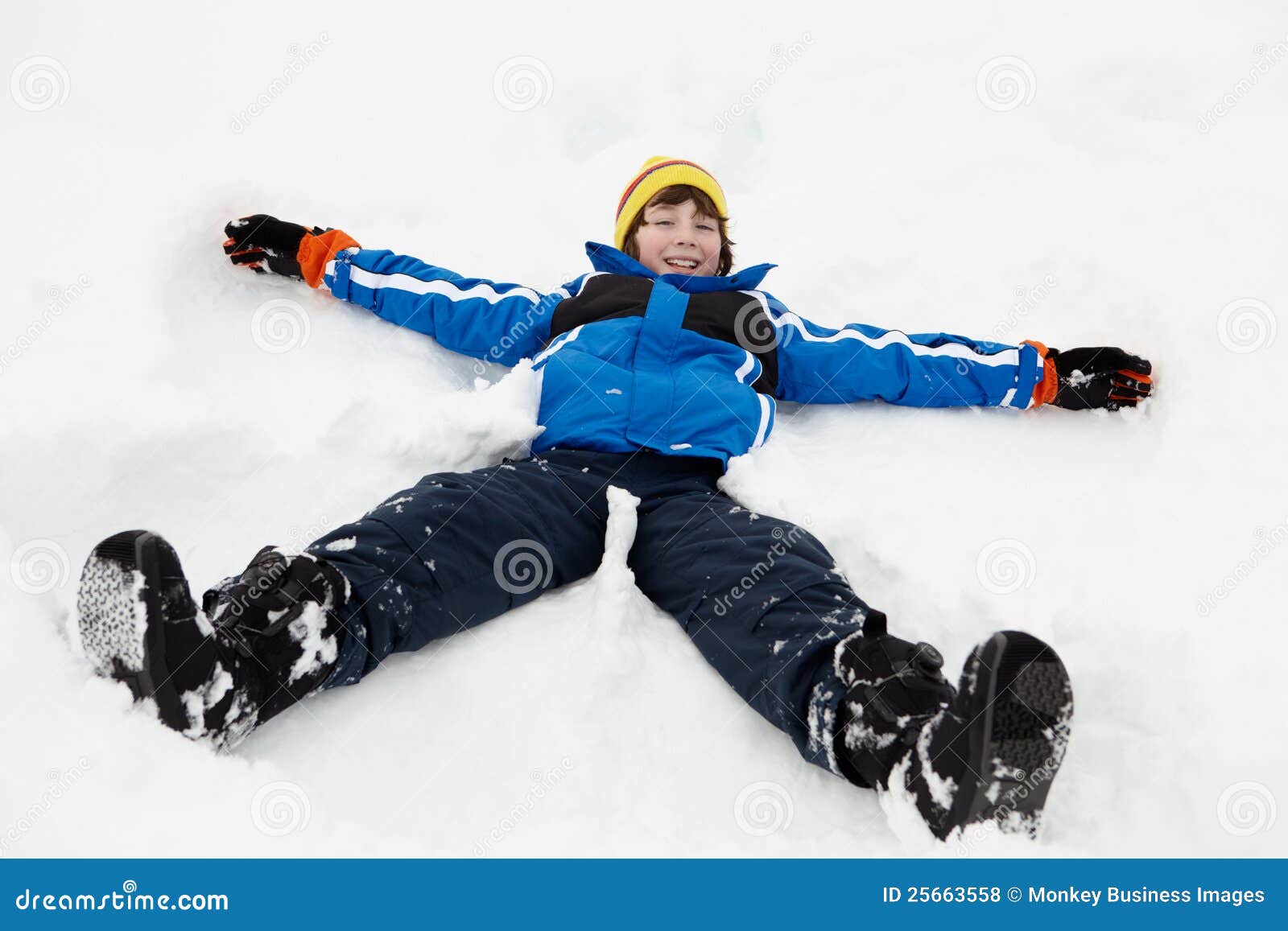 Young Boy Making Snow Angel on Slope Stock Photo - Image of person ...