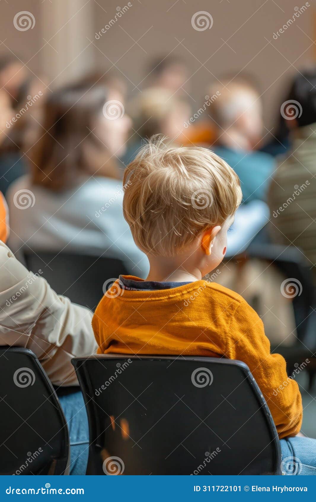 Young Boy in an Orange Shirt Looking Forward with a Focused Expression ...