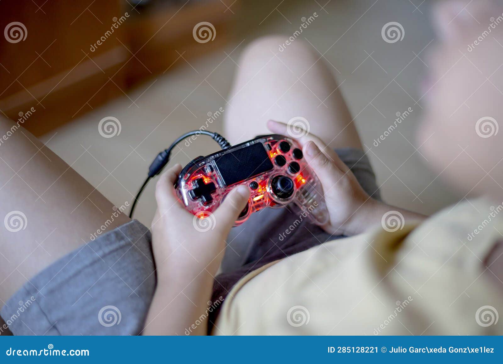 Young Boy Playing a Console Game Sitting on a Pouffe Stock Image ...