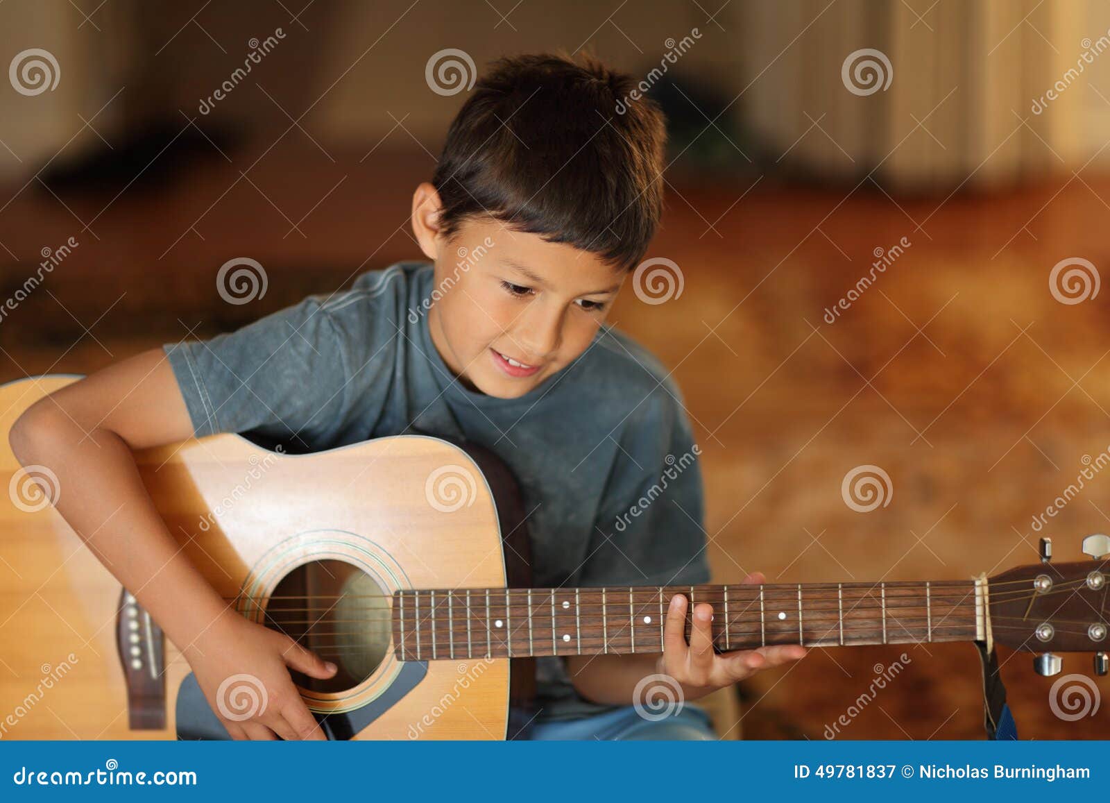 Young boy playing a guitar stock image. Image of indoors - 49781837