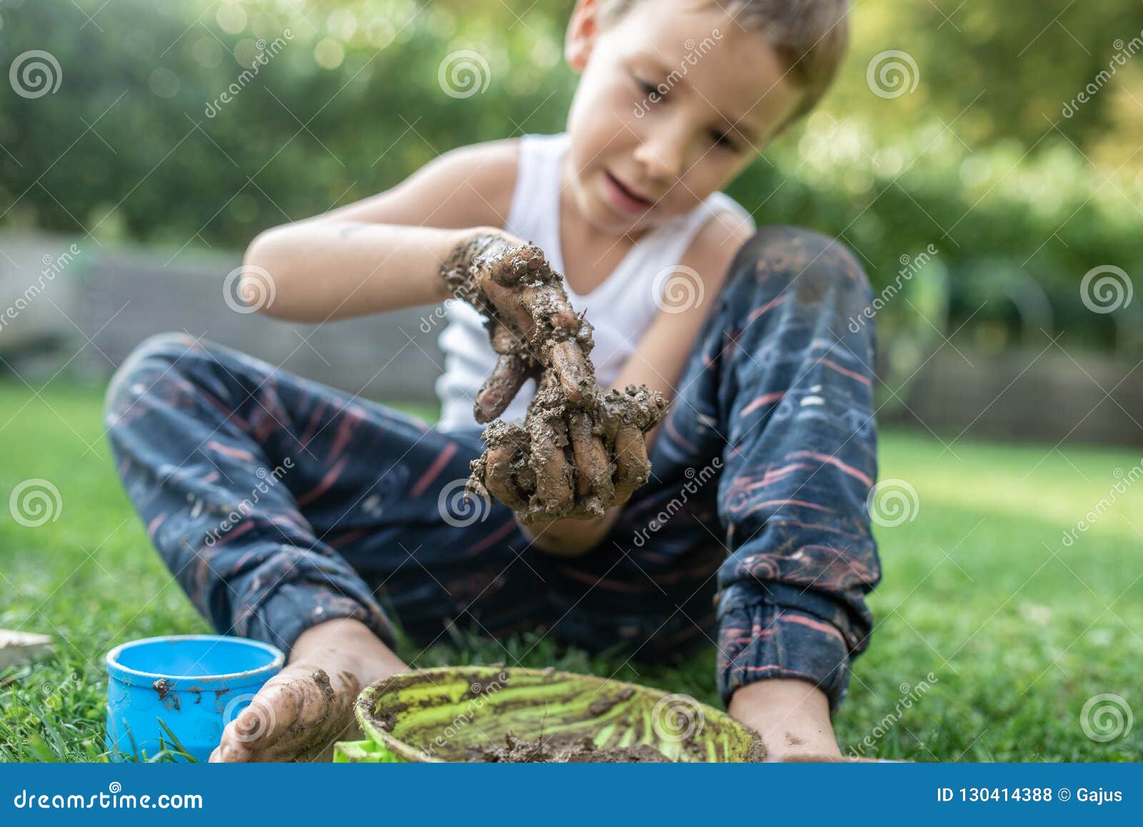 Young boy playing with mud stock photo. Image of nature - 130414388