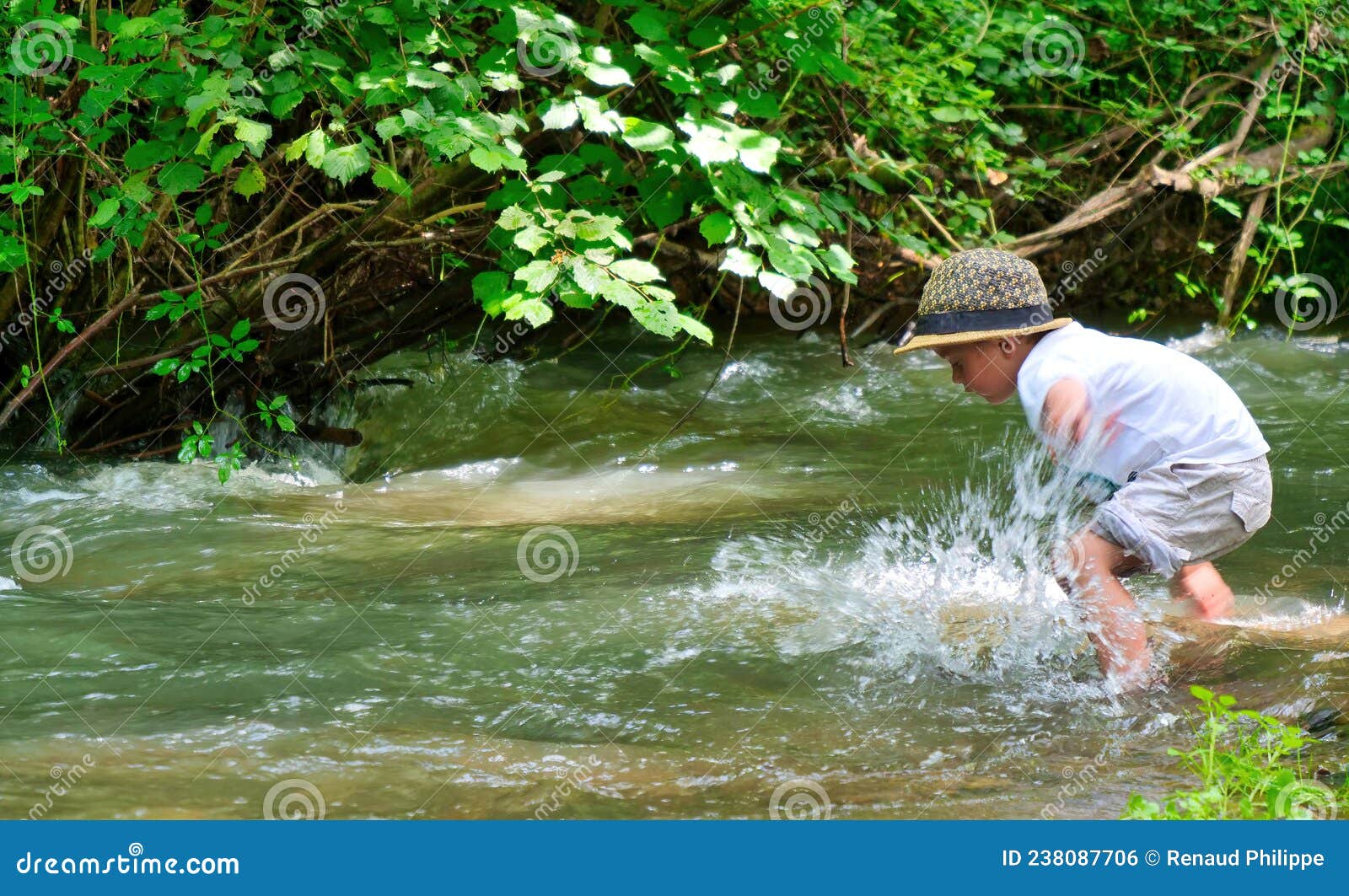 Young boy playing river stock photo. Image of happy - 238087706