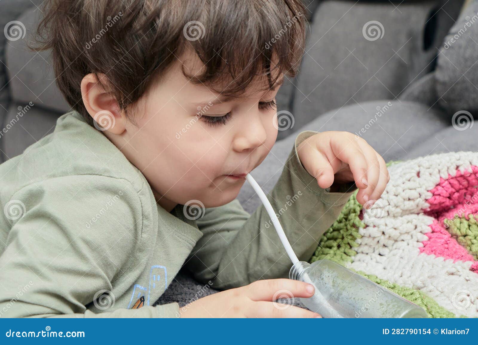 Young Boy Playing with a Straw and Bottle Stock Photo - Image of ...