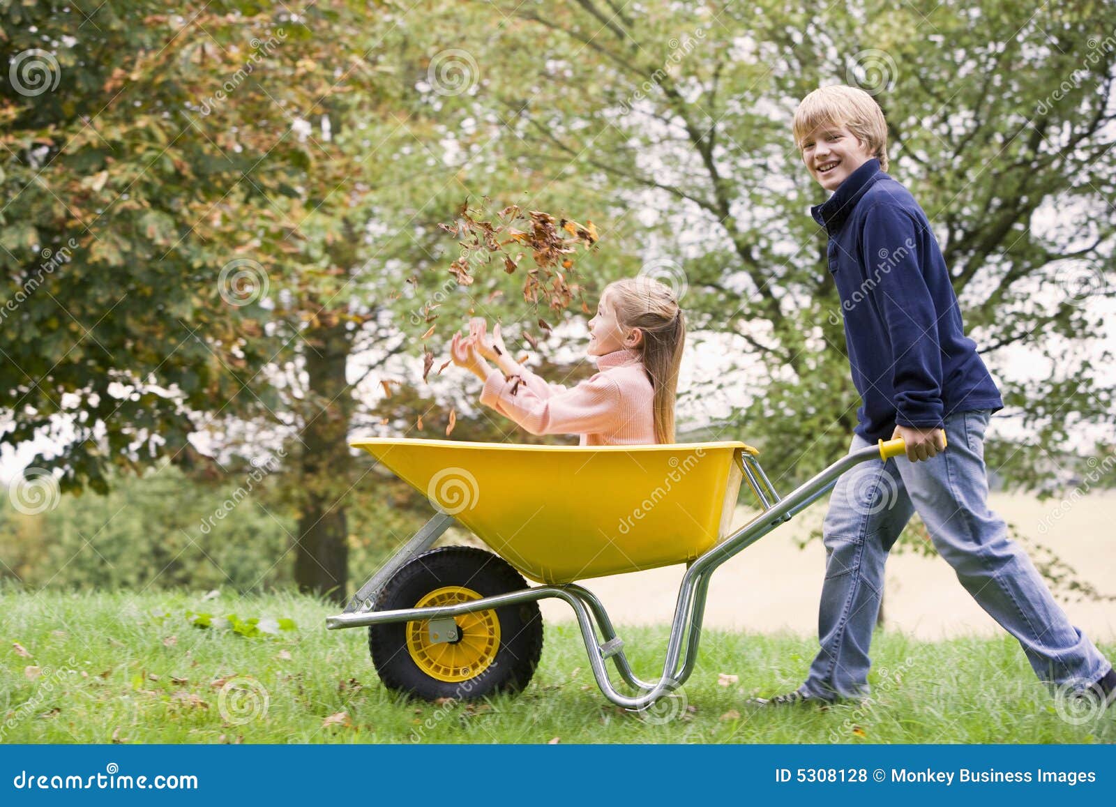 Young Boy Pushing Girl in Wheelbarrow Stock Photo - Image of clothes ...