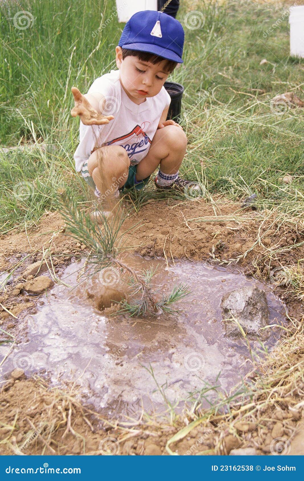 Young boy putting dirt editorial stock photo. Image of children - 23162538