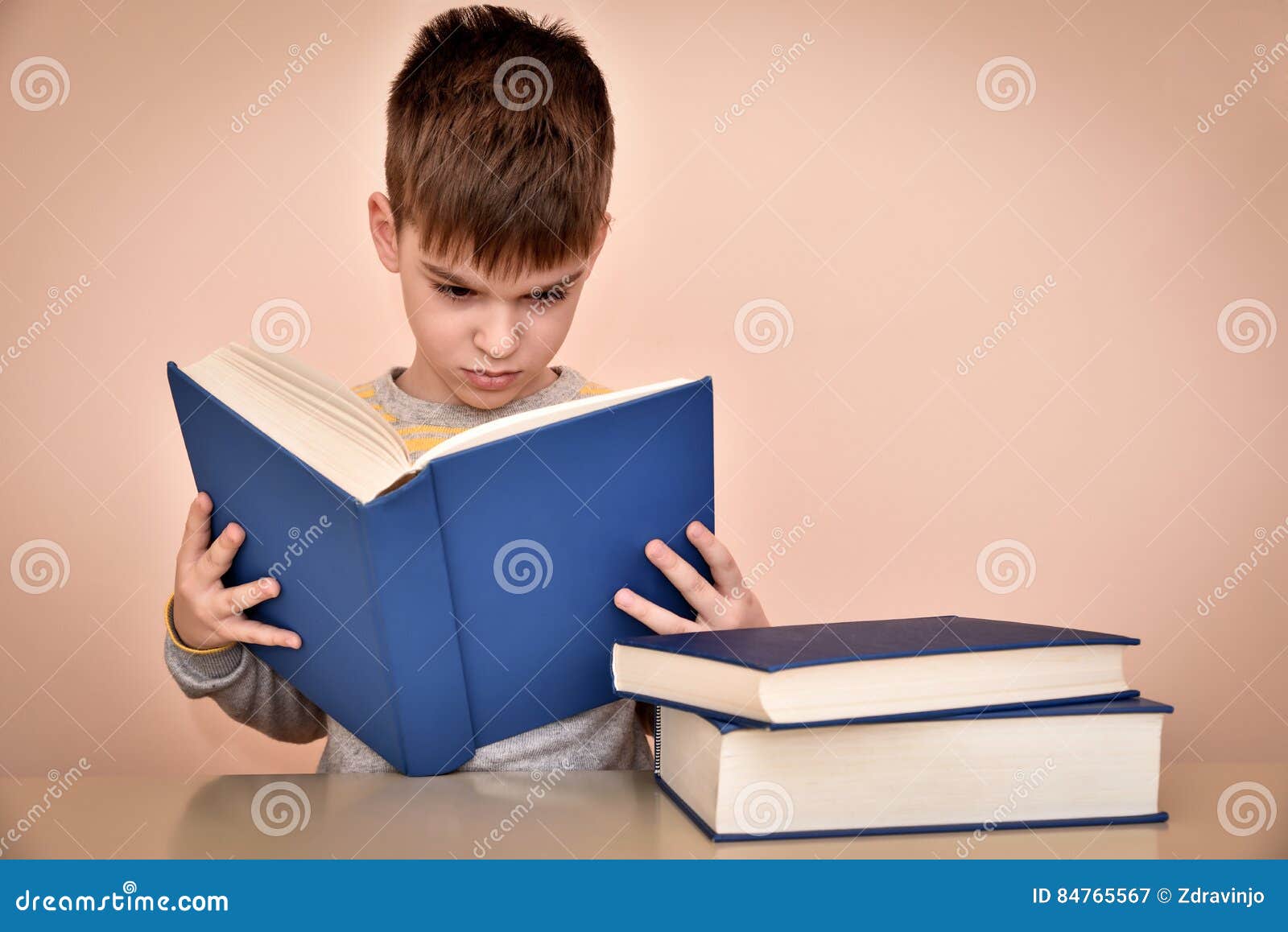 Young boy reading a book stock image. Image of cute, class - 84765567