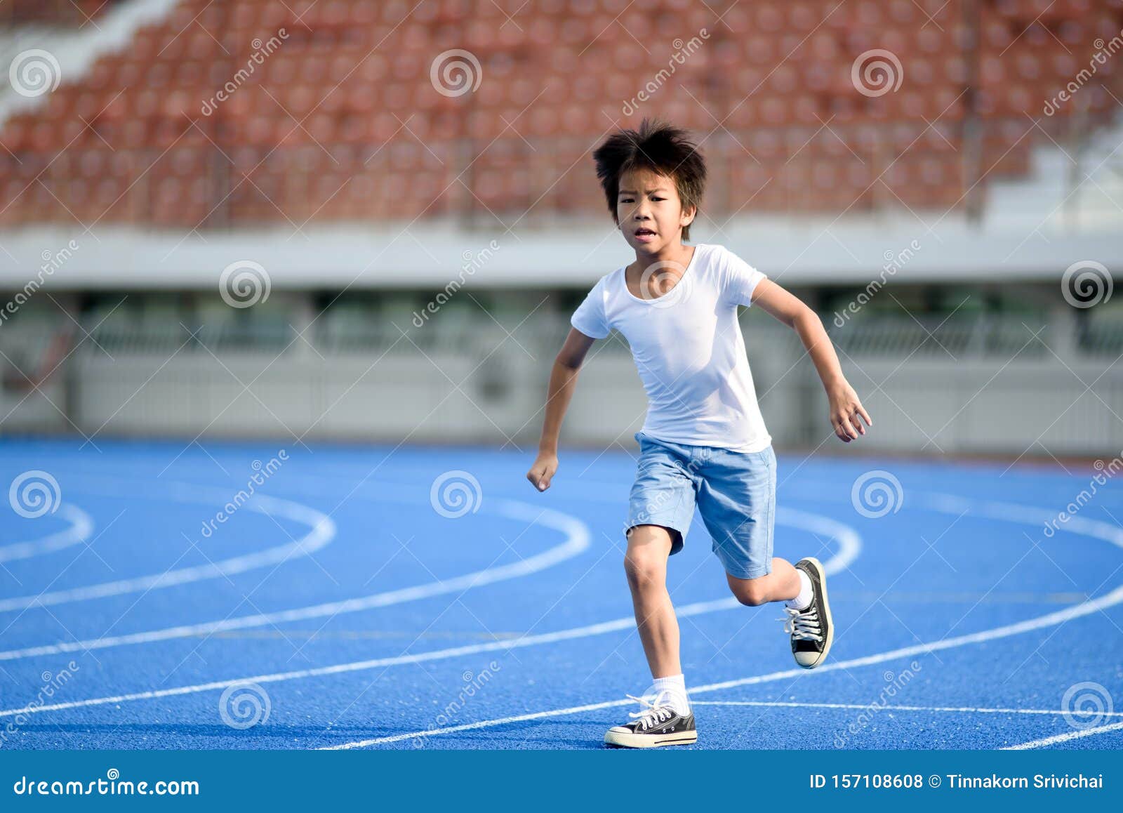 Young Boy Running on Blue Track Stock Photo - Image of blue, energy ...