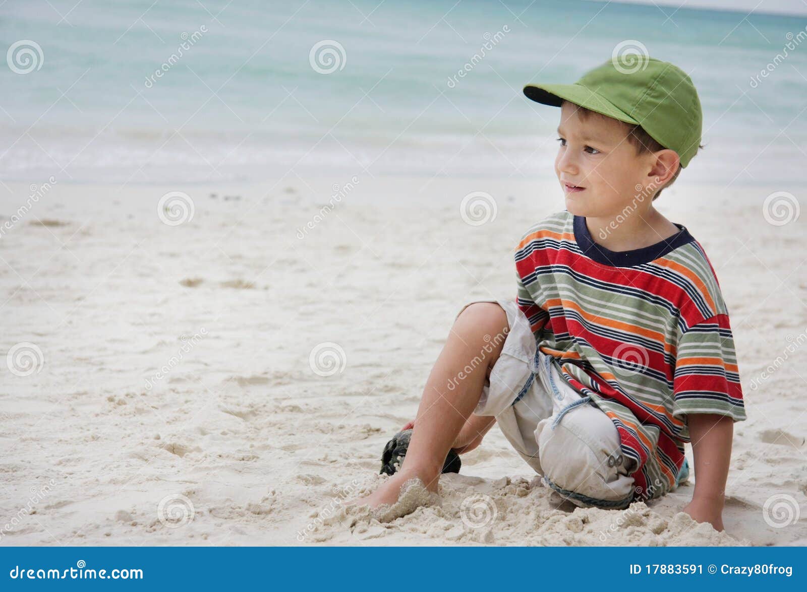 Young boy sitting on beach stock image. Image of small - 17883591