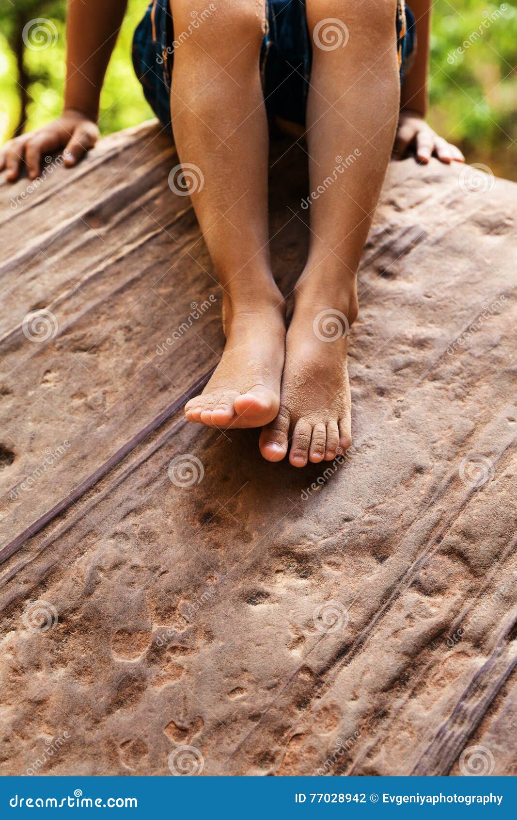 Young boy sitting on rock stock photo. Image of foot - 77028942