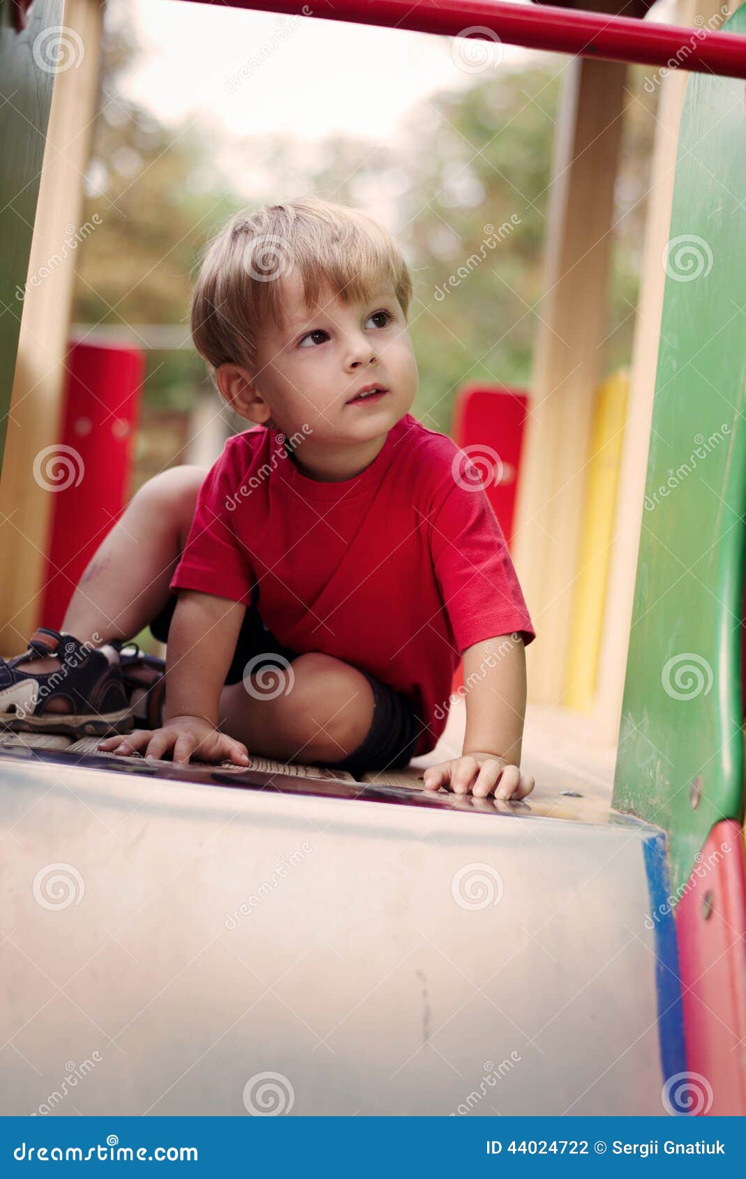Young Boy Sitting at Top of Slide Stock Photo - Image of slide, playing ...
