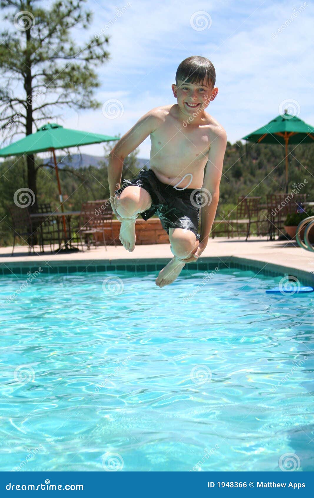 Young Boy Smiling And Jumping Into A Swimming Pool Royalty-Free Stock ...