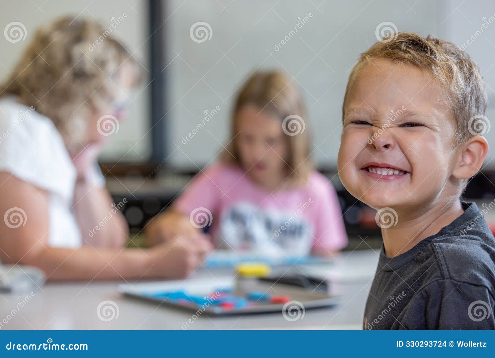 A Young Boy is Smiling and Sitting at a Table in School Stock Photo ...