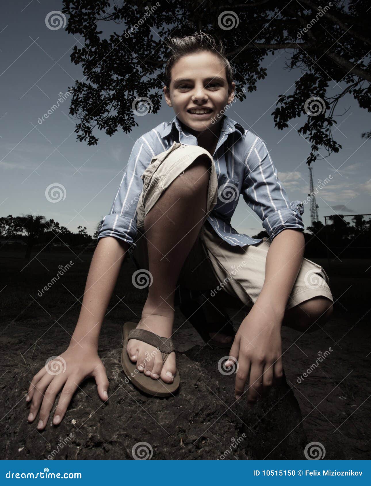 Young Boy Squatting and Smiling Stock Photo - Image of background, blue ...