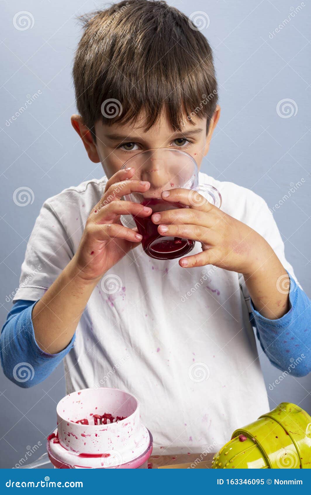 Young Boy Squeezing and Drinking Pomegranate Juice, Making a Mess. Face ...
