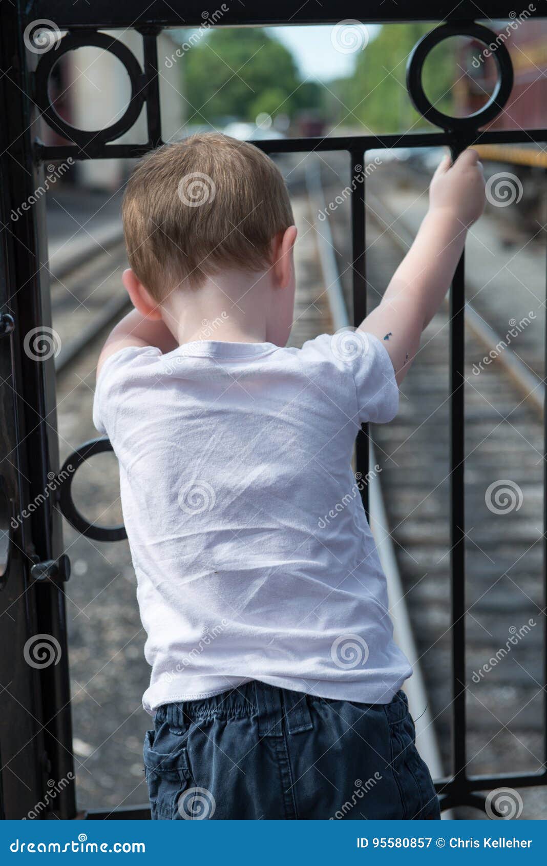 Young Boy Standing at Back of Train Looking Down at Track Stock Image ...