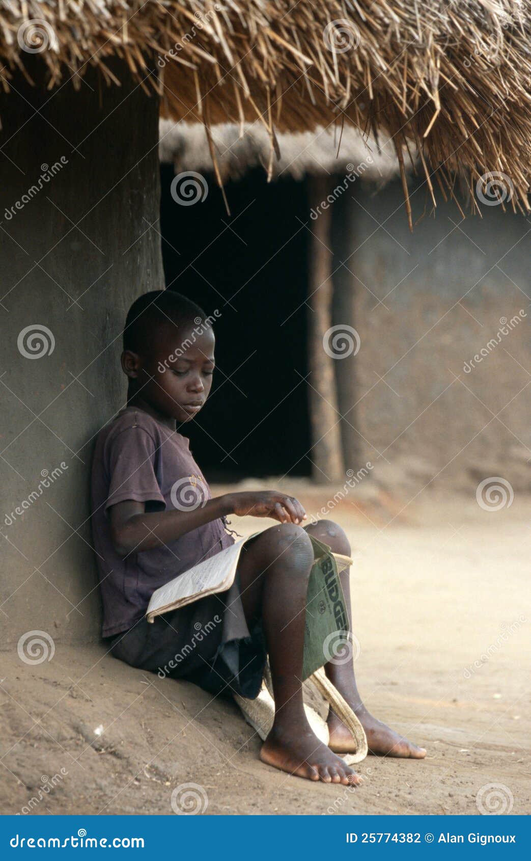 A Young Boy Studying Outside His Hut, Uganda. Editorial Photography ...