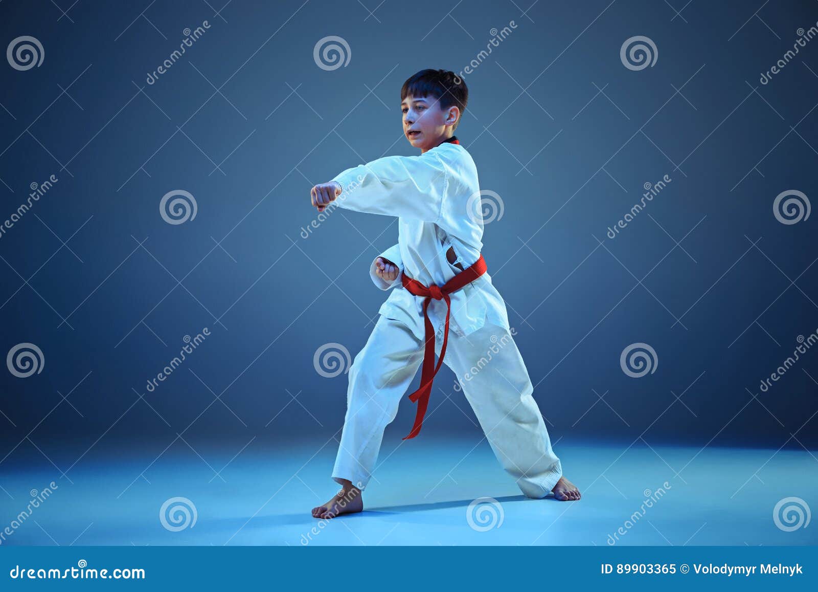 Young Boy Training Karate on Blue Background Stock Image - Image of ...