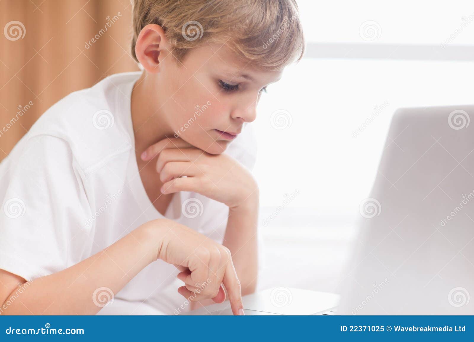 Young boy using a laptop stock image. Image of bedroom - 22371025