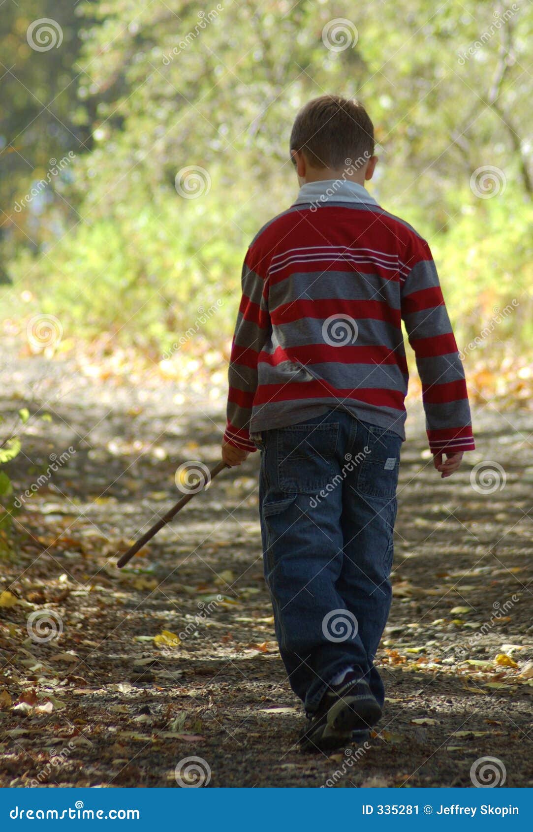 Young Boy Walking with Stick Stock Image - Image of stick, youth: 335281