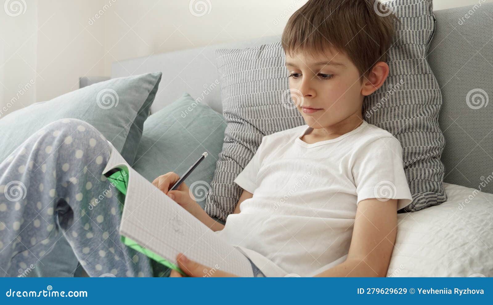 Young Boy Writing in His Notebook while Lying in Bed. Essence of ...