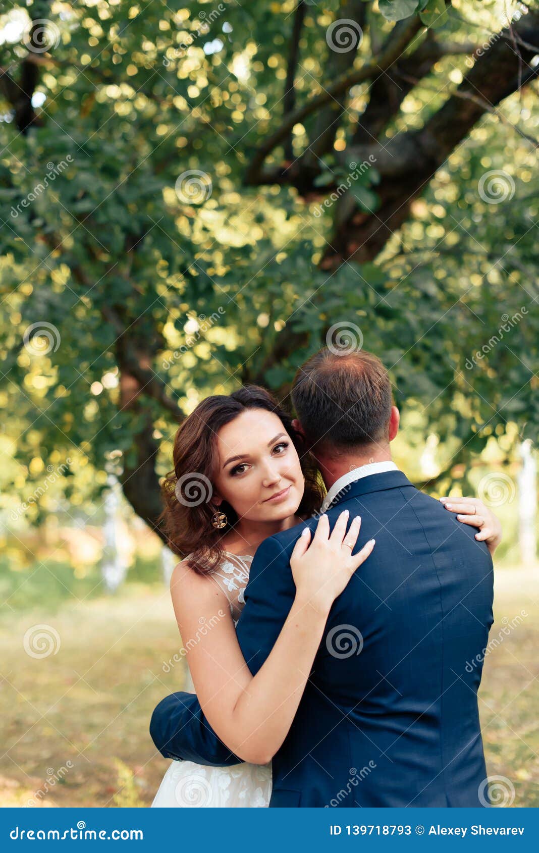Young Bride and Groom Walking in a Summer Park with Green Trees Stock ...