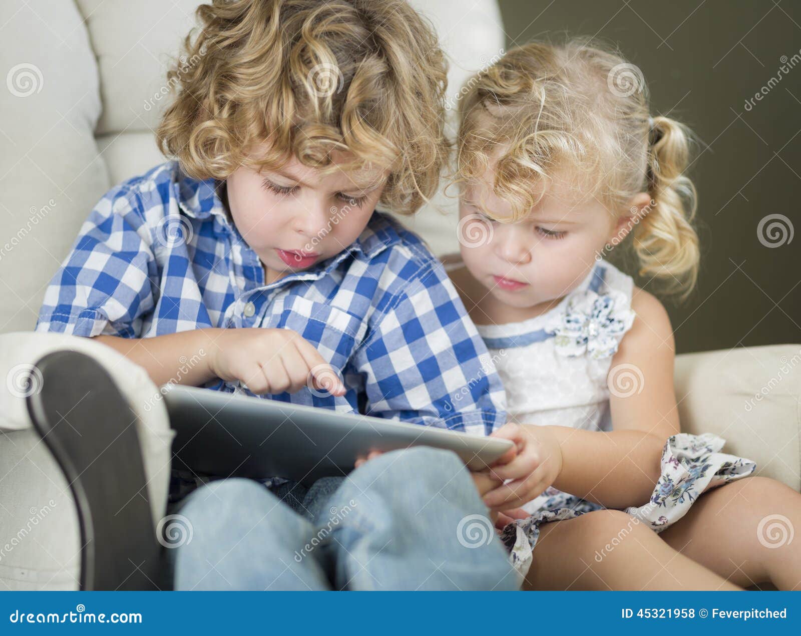 Young Brother and Sister Using Their Computer Tablet Together Stock ...