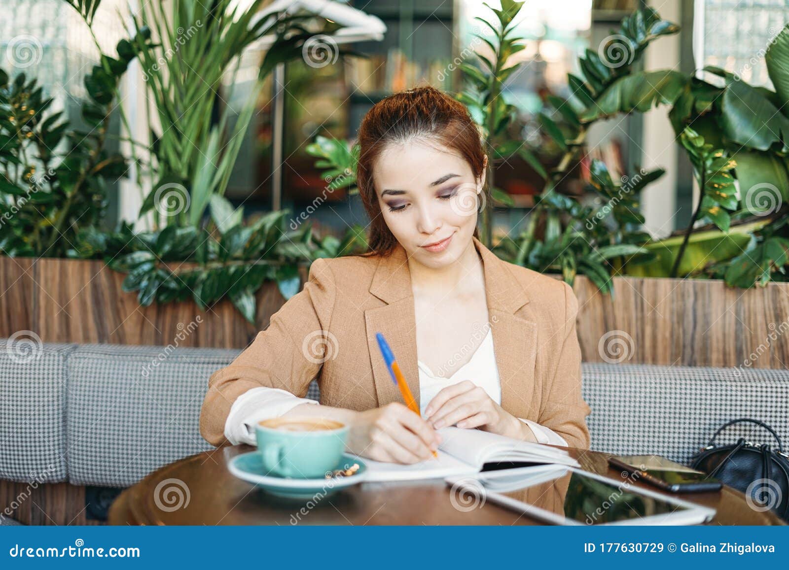 Young Brunette Girl Student Doing Homework in Notebook with Coffee ...