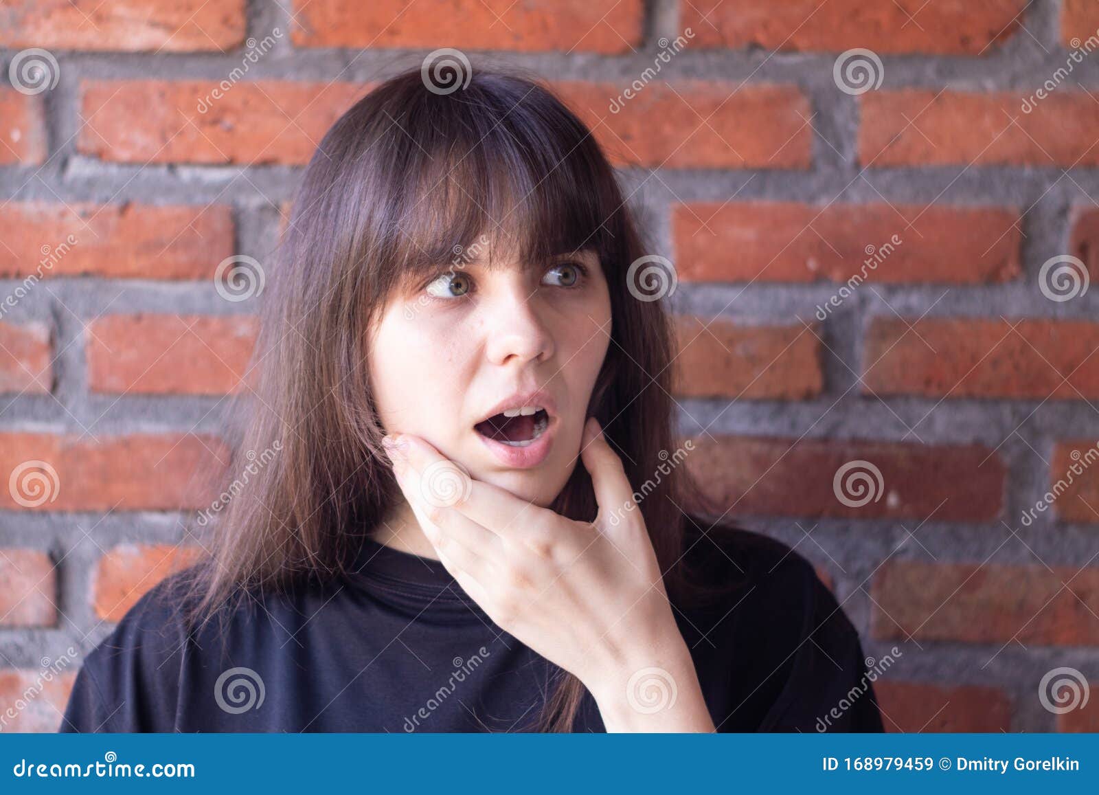 Young Brunette Woman With Bangs Wearing A Black T-shirt Shock By An ... Young Brunette Woman With Bangs Wearing A Black T-shirt Shock By An ...