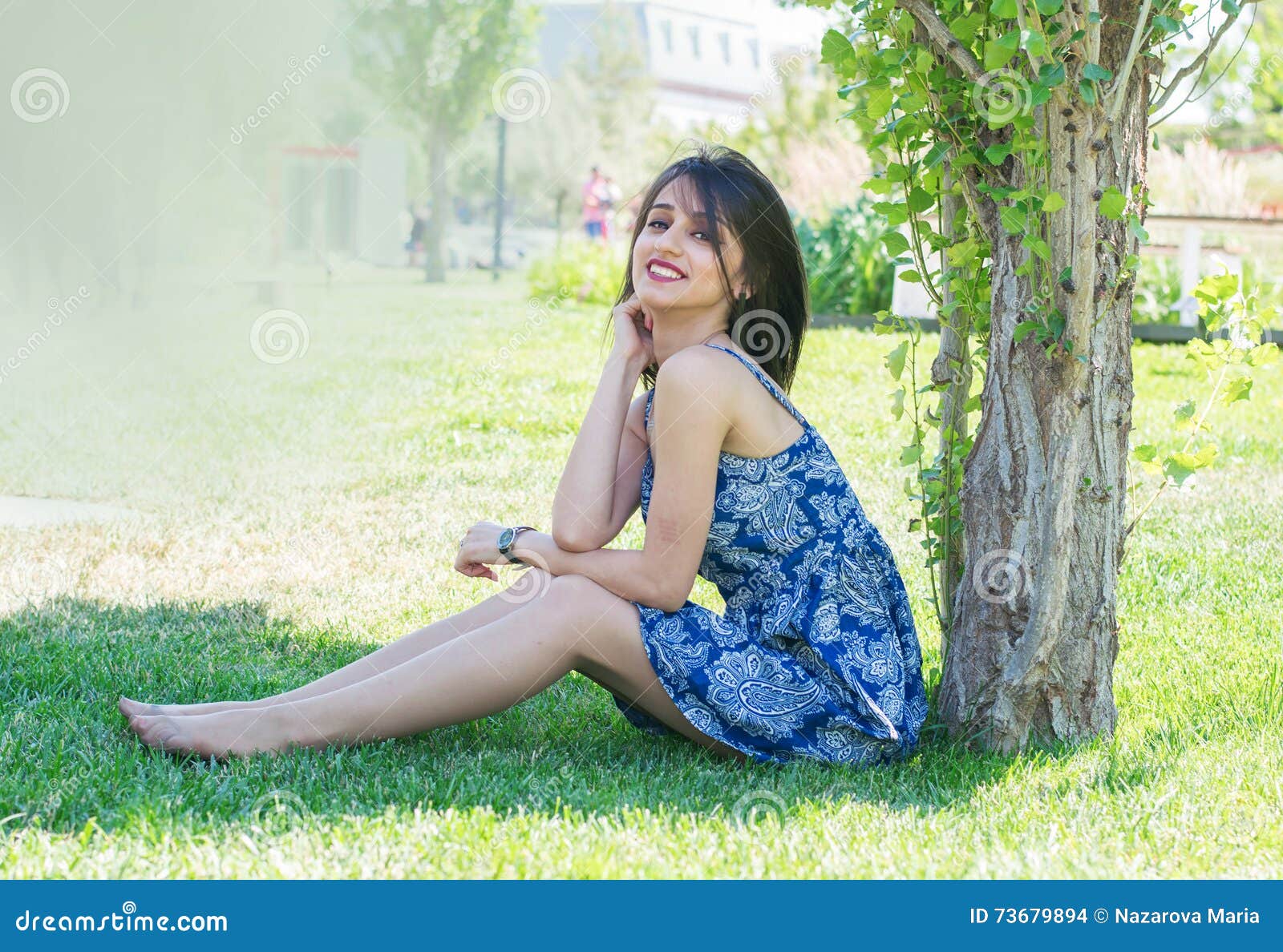 Young Brunette Woman Sitting on the Lawn Under a Tree Stock Photo ...