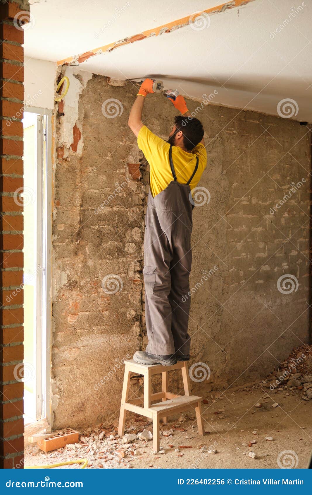 Young Builder Breaking Up a House Wall with a Hammer and a Chisel ...