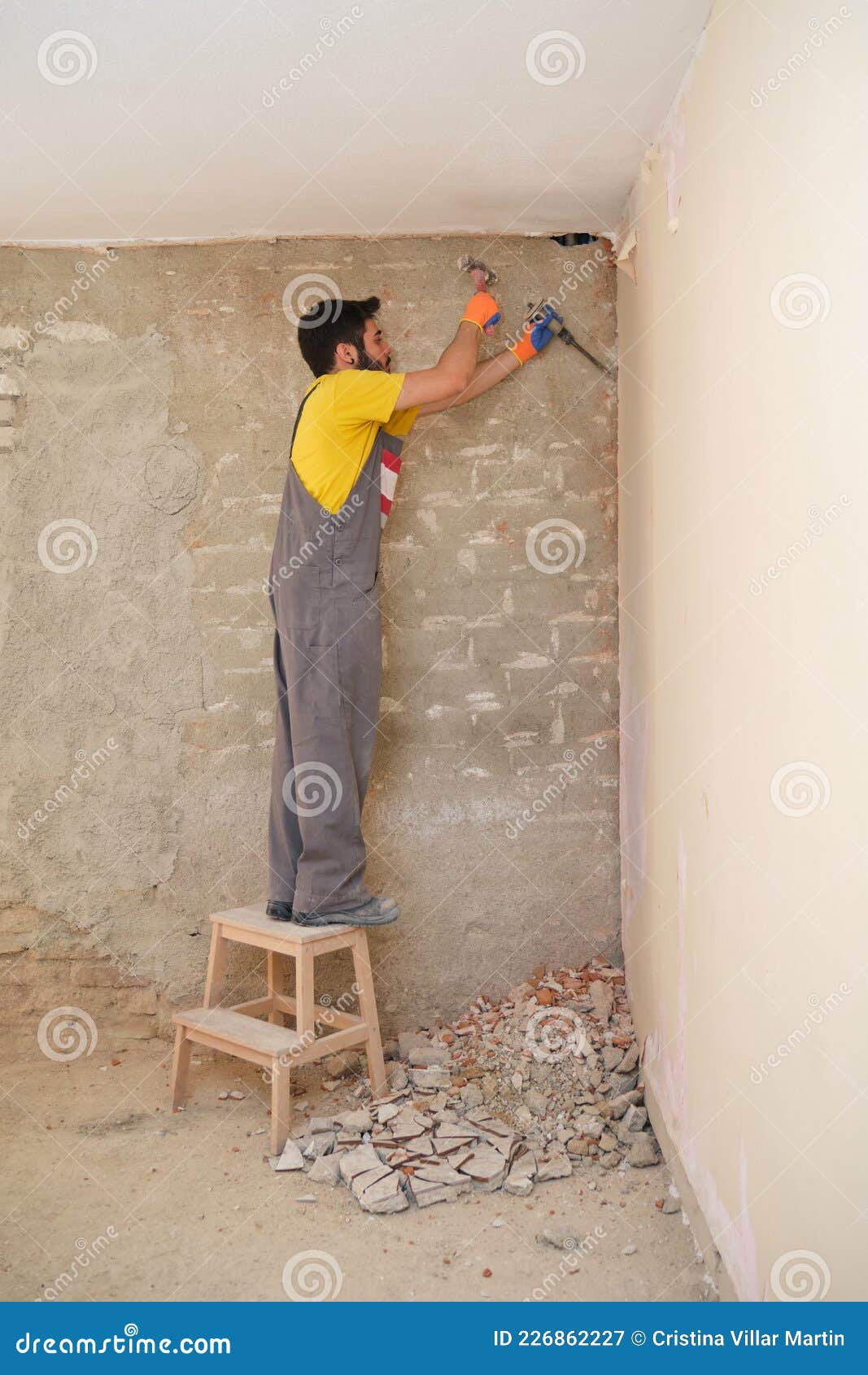 Young Builder Breaking Up a House Wall with a Hammer and a Chisel ...