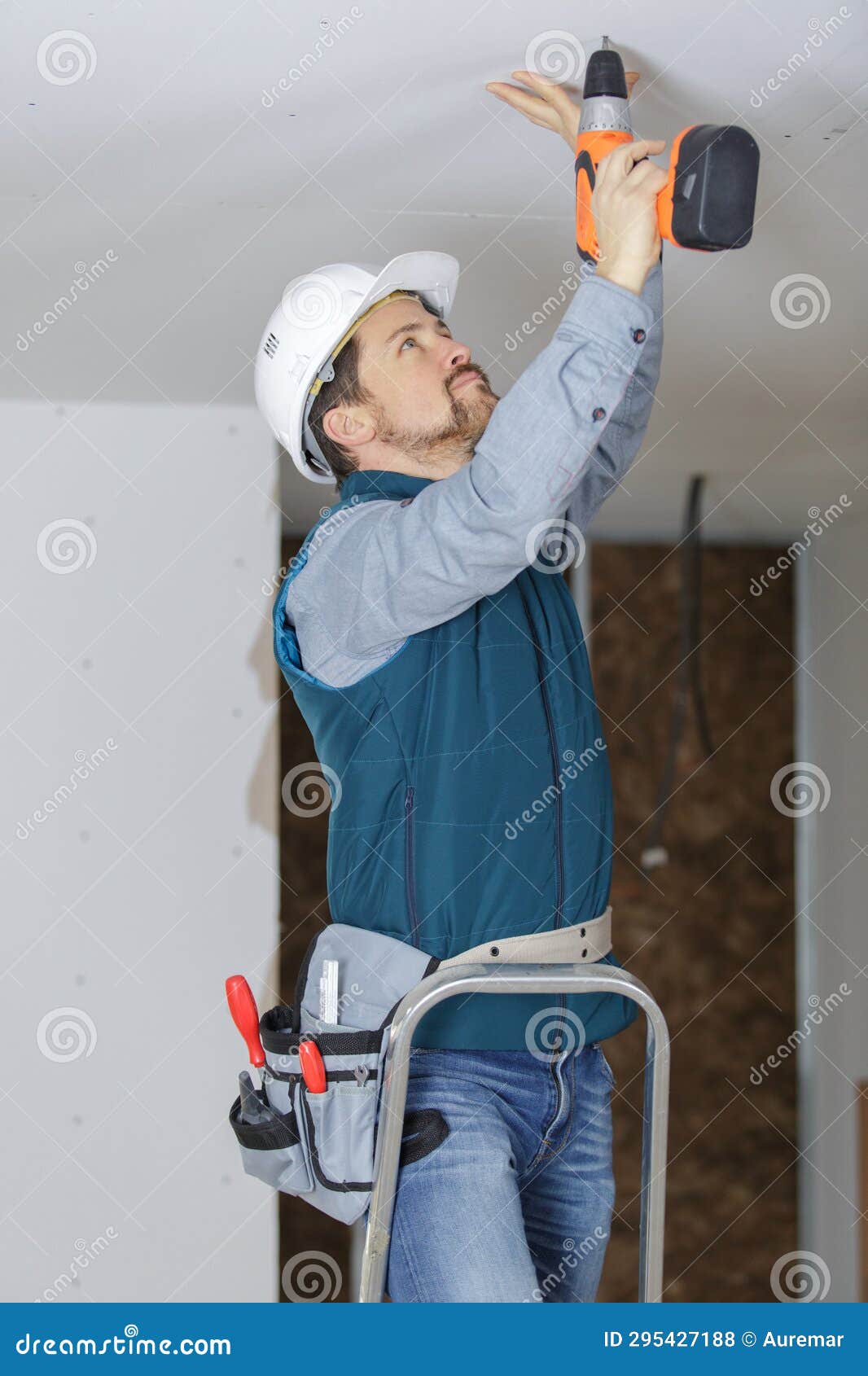 Young Builder Up Ladder Drilling Ceiling Stock Photo - Image of ...