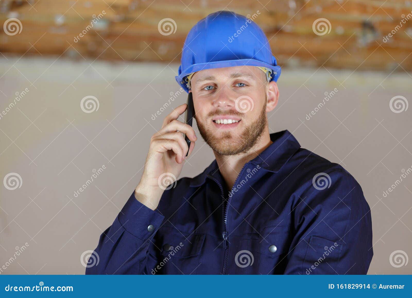 Young Builder in Workwear Using Mobile Phone Stock Photo - Image of ...