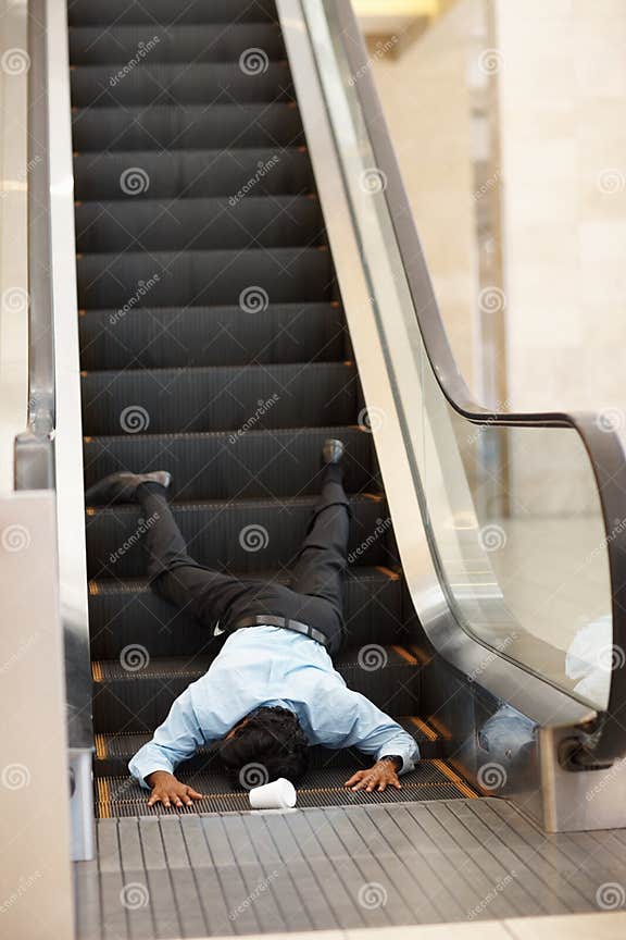 Young Business Man Fallen at the Escalator Stock Image - Image of faint ...