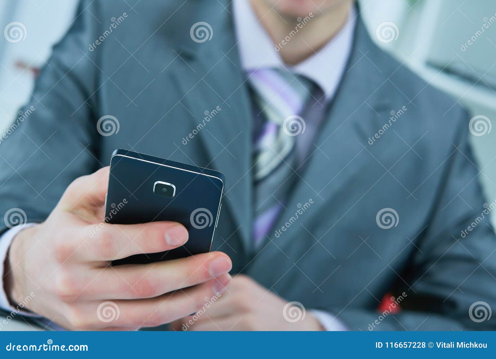 Young Business Man Reading Message With Smartphone In Office Stock