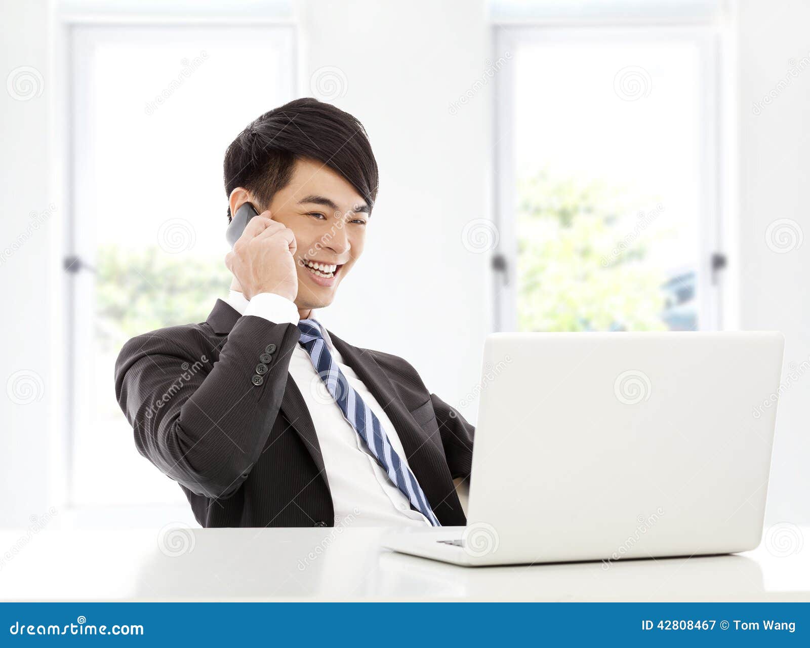 Young Business Man Talking Happily by Smart Phone in Office Stock Image ...