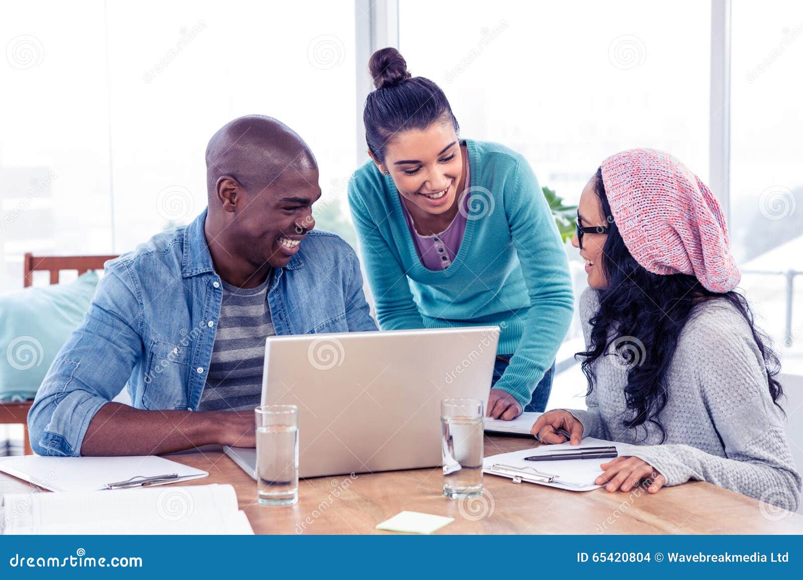 Young Business People Discussing Over Laptop in Office Stock Photo ...