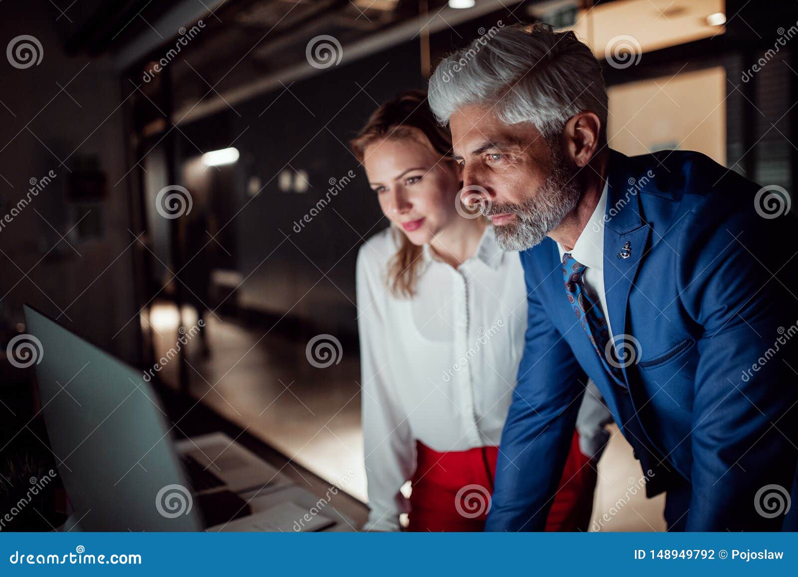 Young Business People in an Office at Night, Using Computer. Stock ...