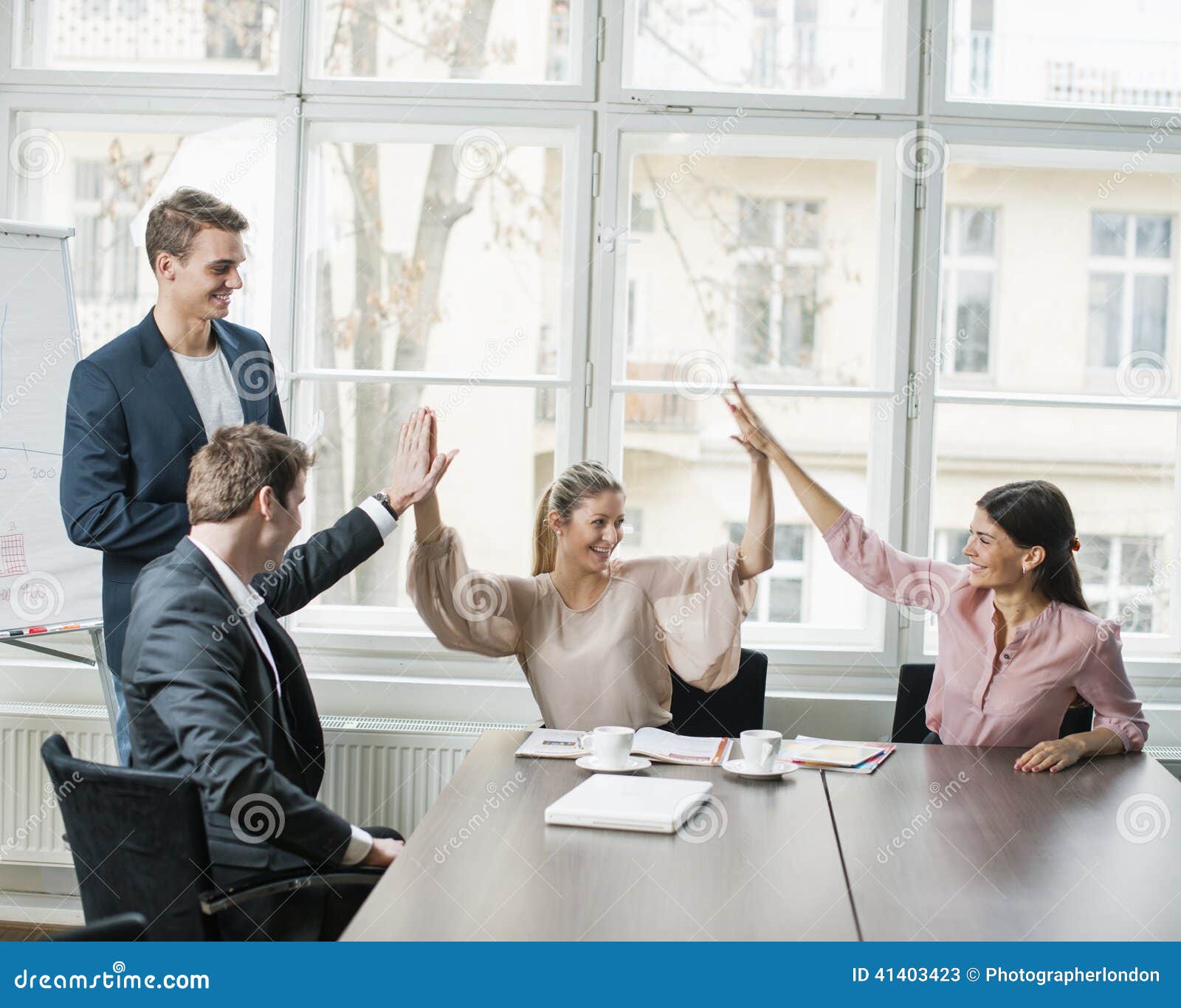 Young Business Team Doing High Five at Conference Table Stock Image ...
