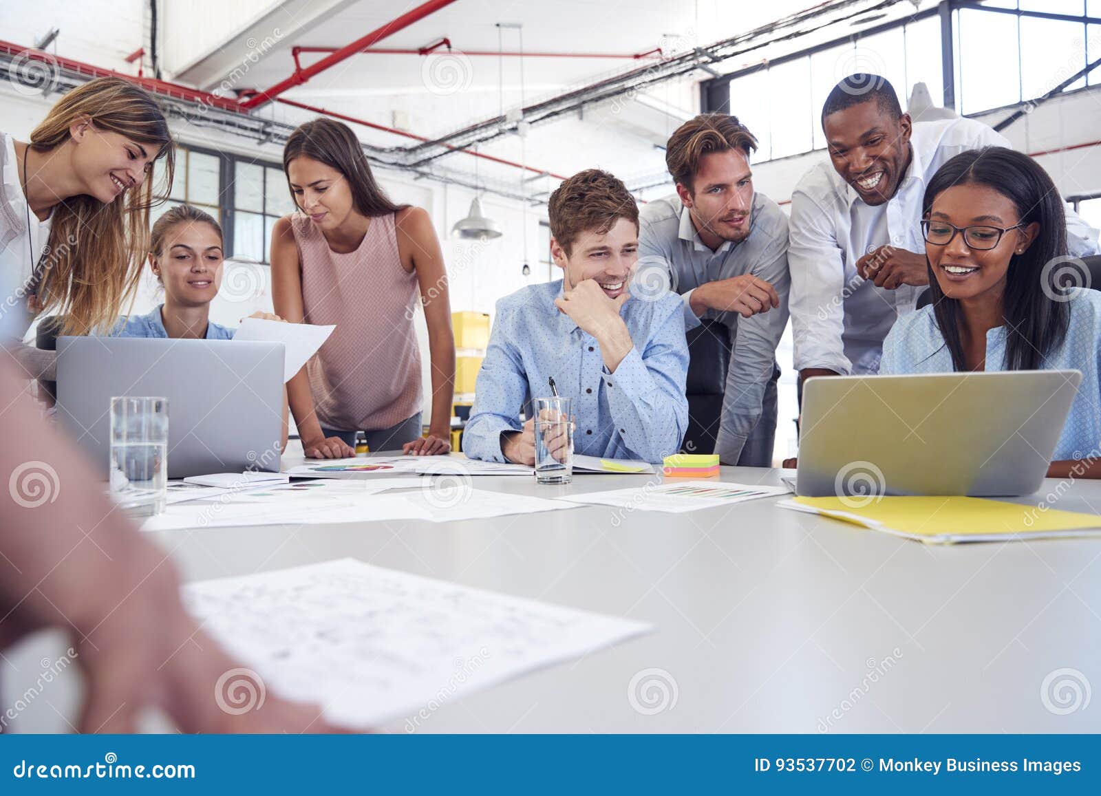 Young Business Team Gathered Around Two Laptops in an Office Stock ...