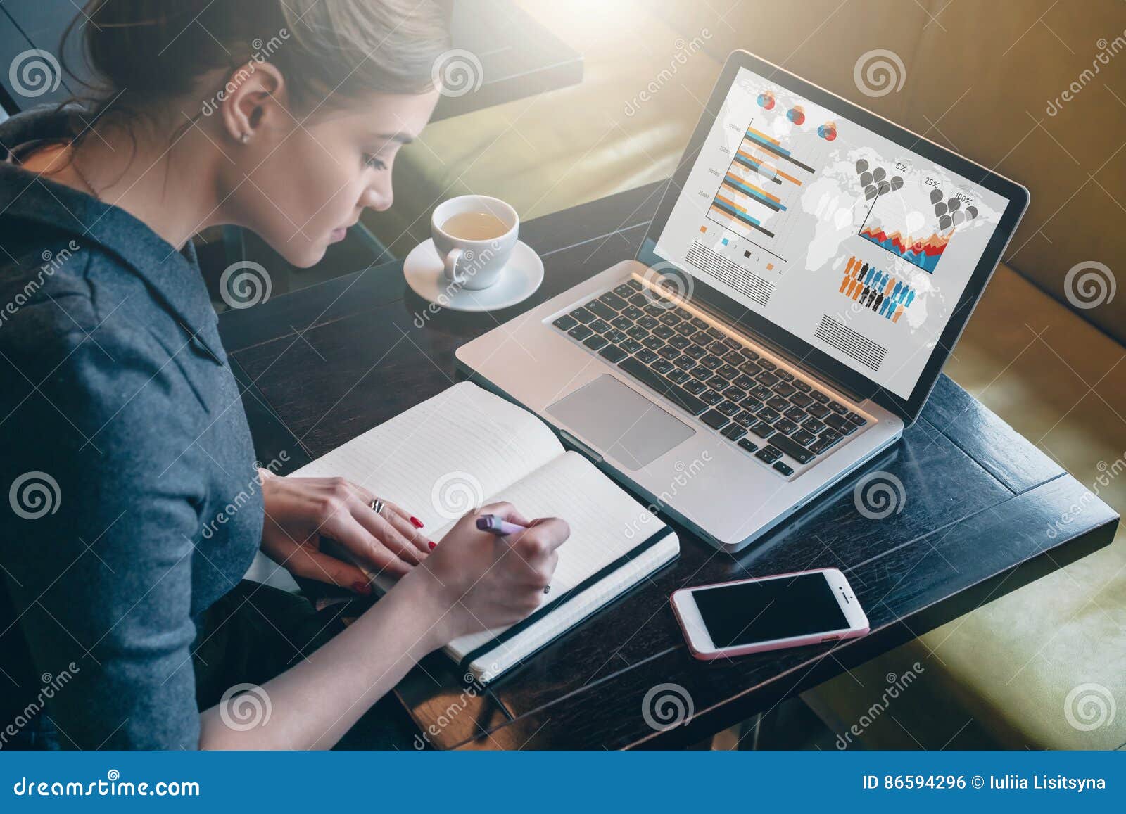 Young Business Woman Sitting at Table and Taking Notes in Notebook.on ...