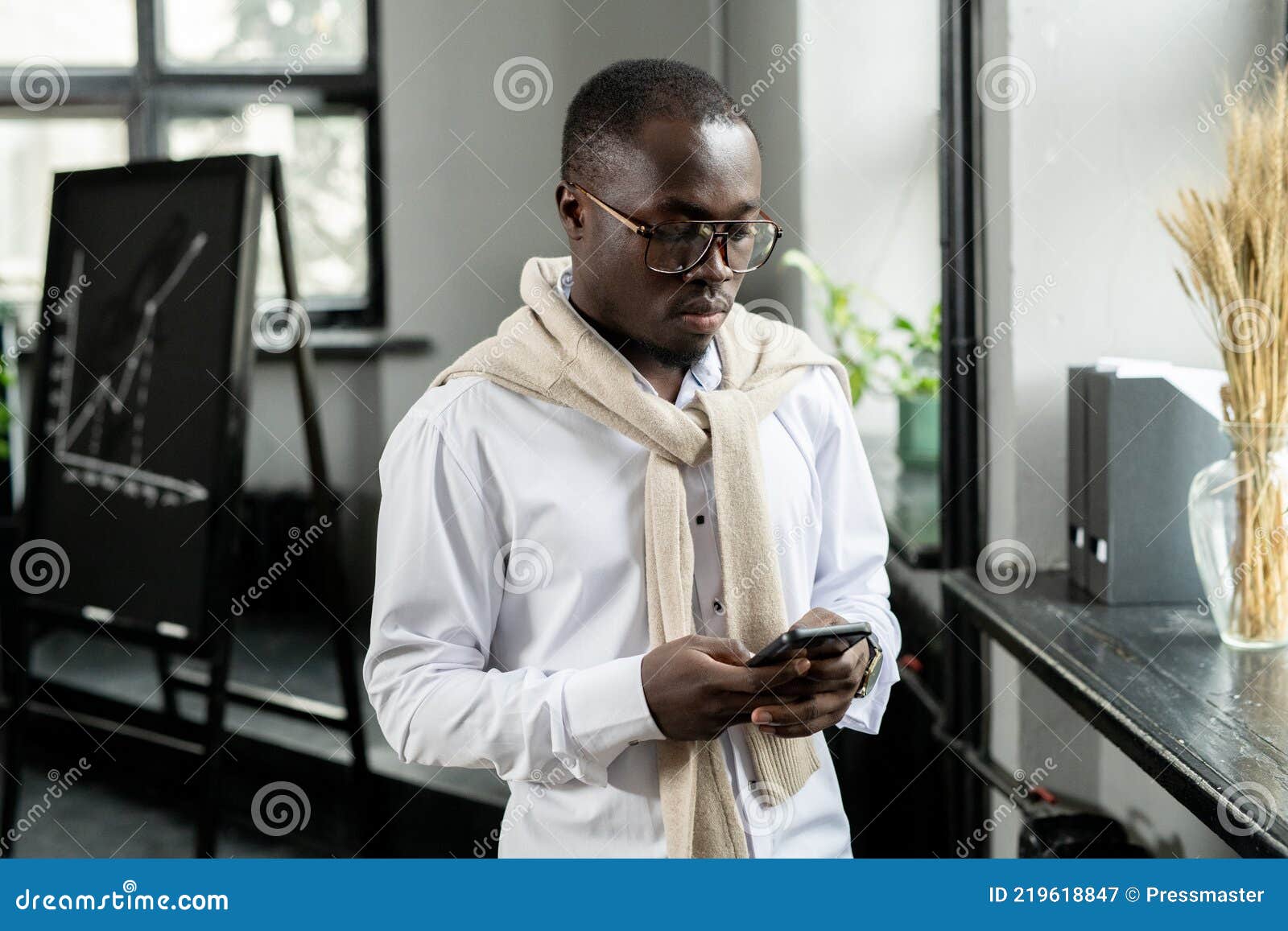 Young Businessman of African Ethnicity Scrolling in Smartphone Stock ...
