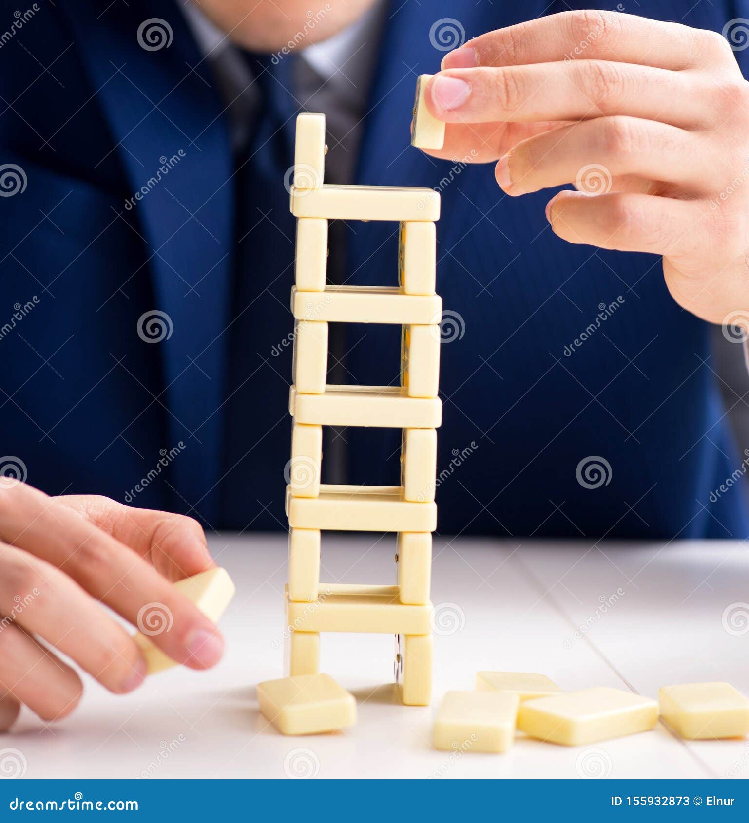 Young Businessman Building Domino Tower in Office Stock Image - Image ...